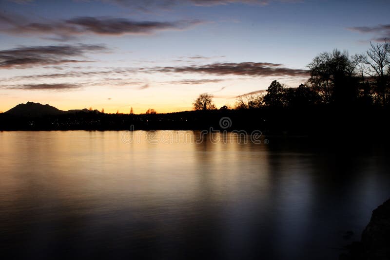 Twilight by the Lake in Cham, Zug with the Swiss Alps Stock Photo ...