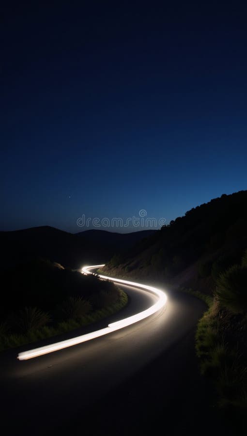 A Twilight Road with Headlightlit Curves Set Amidst a Starry Night Sky ...