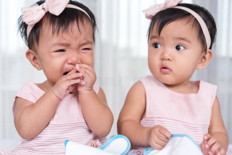 Twin Babies in Pink Dress, One Looking, One Crying Stock Image - Image ...