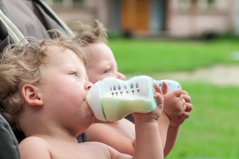 Twins Suck a Bottle with Milk Stock Image - Image of person, child ...
