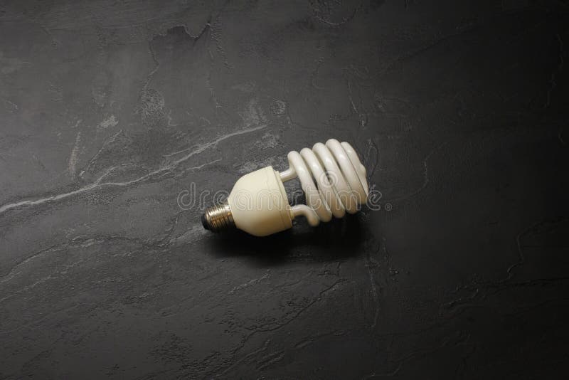 Twisted Lightbulb on a Black Surface Stock Photo - Image of technology ...