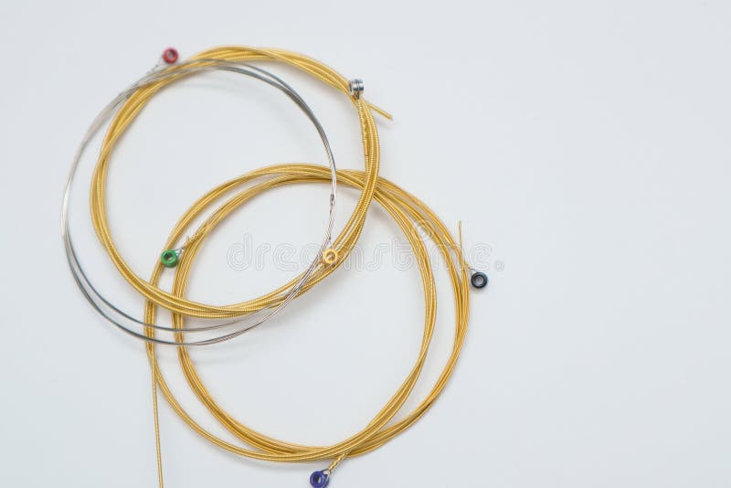 Twisted New Guitar Strings on White Background. New Acoustic Guitar ...