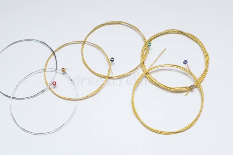 Twisted New Guitar Strings on White Background. New Acoustic Guitar ...