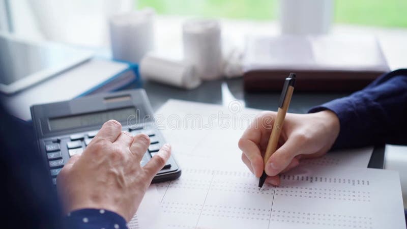 Two Accountants Dressed in Blue are Using Calculator for Counting Taxes ...
