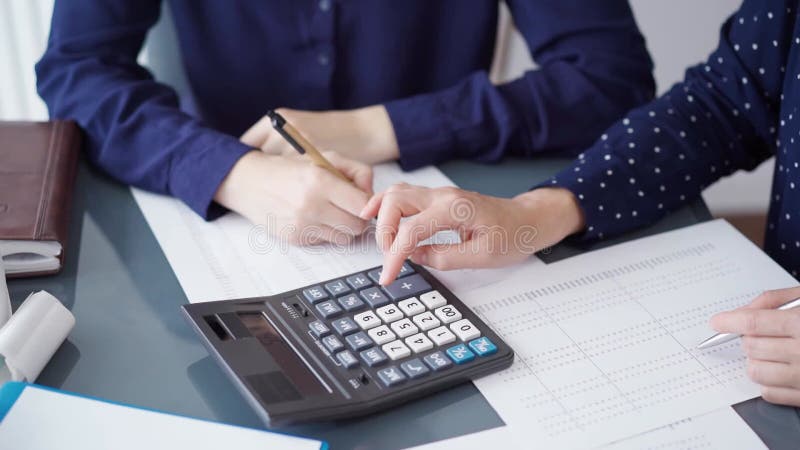 Two Accountants Dressed in Blue are Using Calculator for Counting Taxes ...