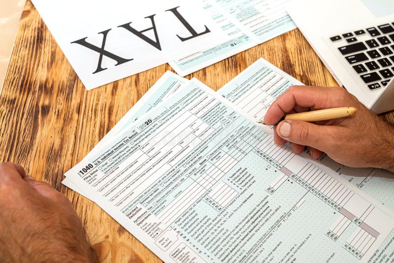 Two Accountants Fill in Tax Forms 1040 in Two Hands on a Spacious Table ...