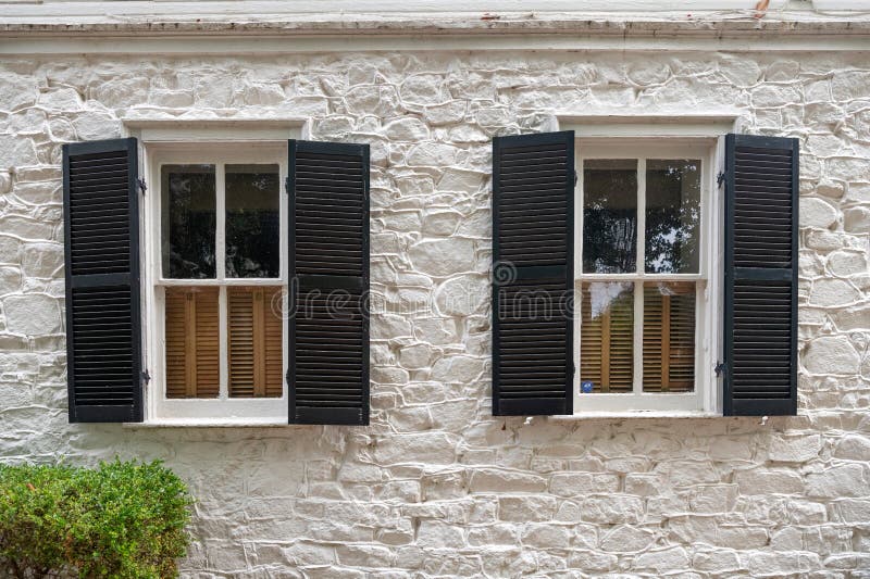 Two Antique Windows with Shutters in the Wall of an Old White Stone ...