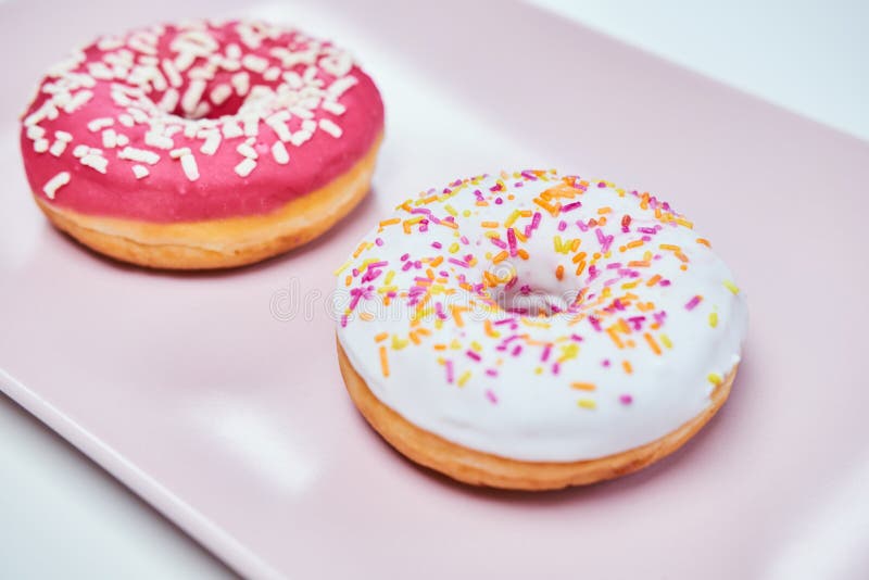 Two Appetizing Donuts Lie on a Pink Ceramic Plate. Stock Image - Image ...