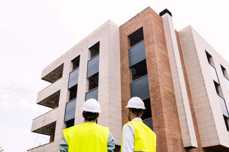 Two Architect Engineers Looking at Building Construction Outdoors Stock ...