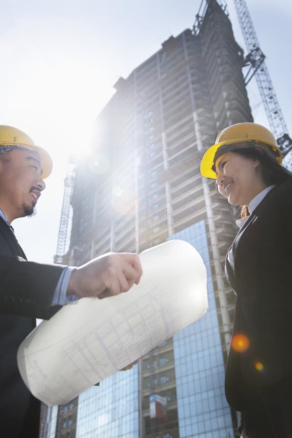 Two Architects at a Construction Site Holding Blueprint Stock Image ...