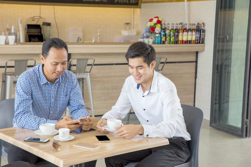 Two Asian Businessmen Discussing while Having Coffee Together Stock ...
