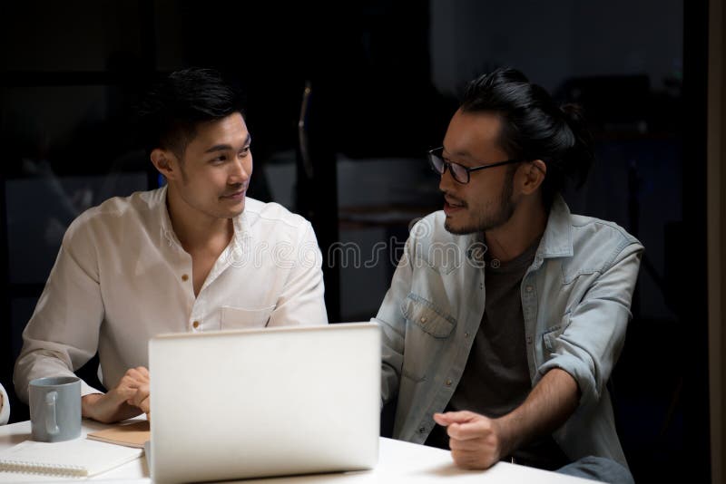 Two Asian Businessmen Using Computer To Discuss Work in the Office at ...