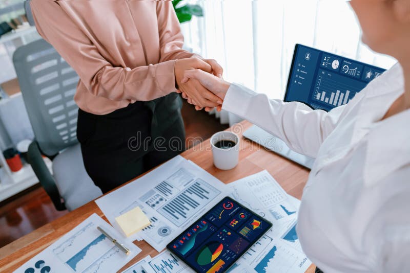 Two Asian Businesswomen Handshake in Modern Office with Data Paper ...