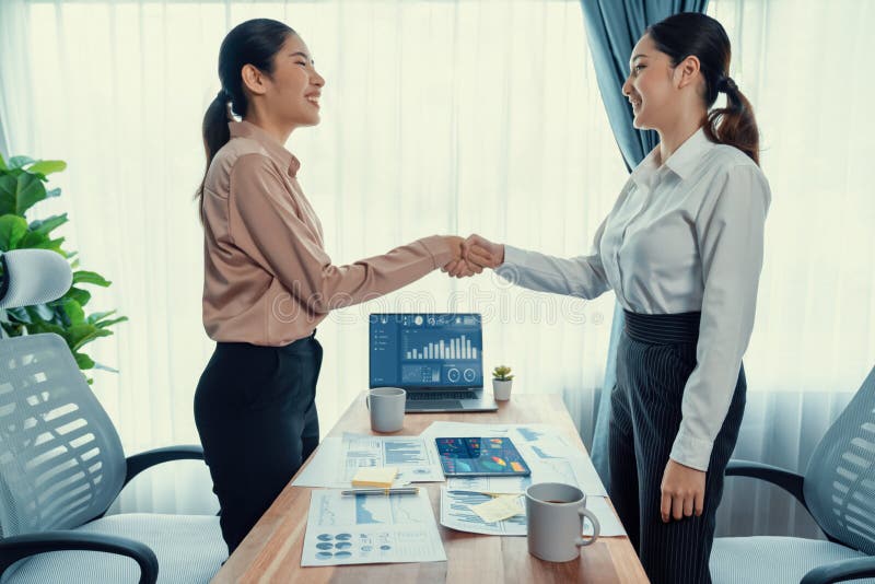 Two Asian Businesswomen Handshake in Modern Office with Data Paper ...