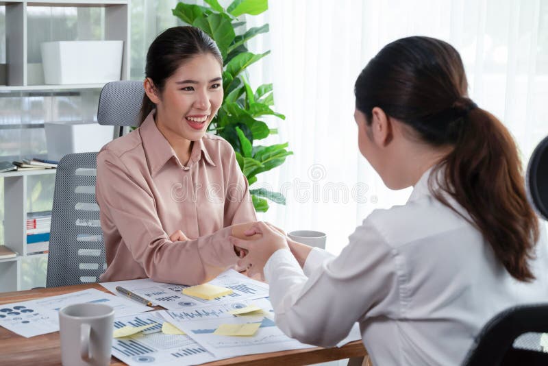 Two Asian Businesswomen Handshake in Modern Office with Data Paper ...