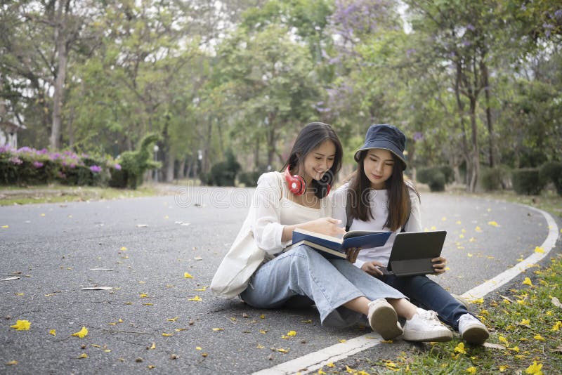 Two Asian College Student Sitting in College Campus and Making Research ...