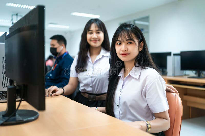 Asian Female Students Sitting Side by Side in Front of a Computer Stock ...