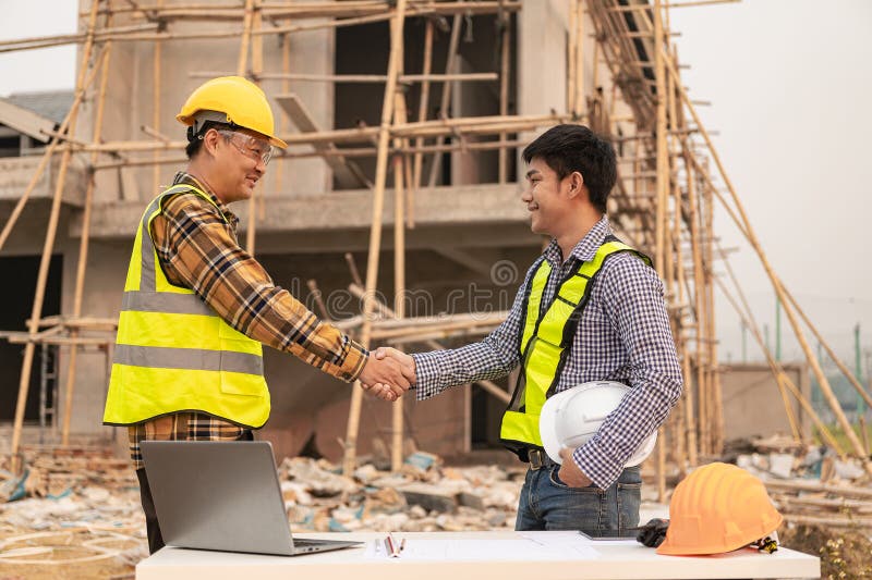 Two Asian Male Engineers Shaking Hands and Working Together Hope Stands ...