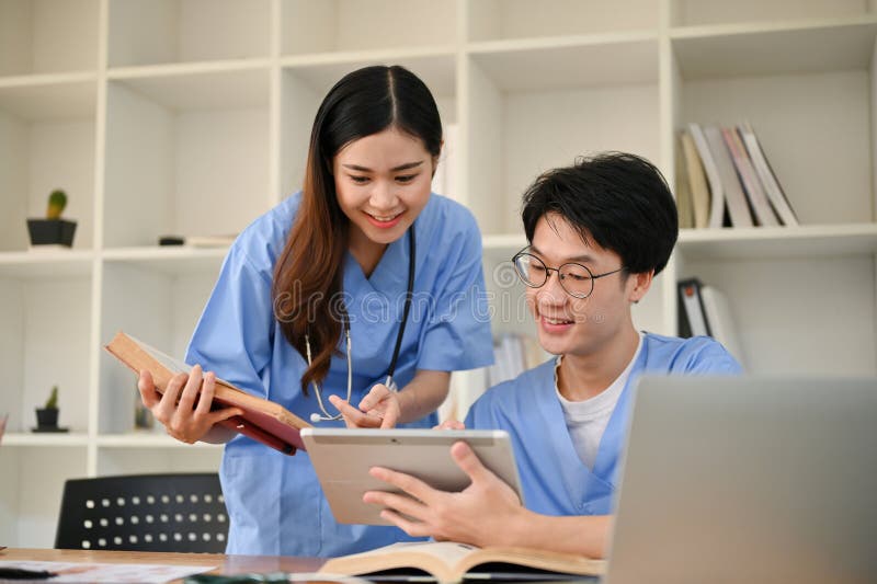 Two Asian Medical Students are Talking, Using Tablet and Researching ...