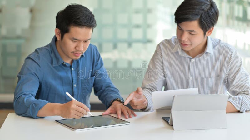 Two Asian Men are Using Tablet To Create Their Work To Present ...