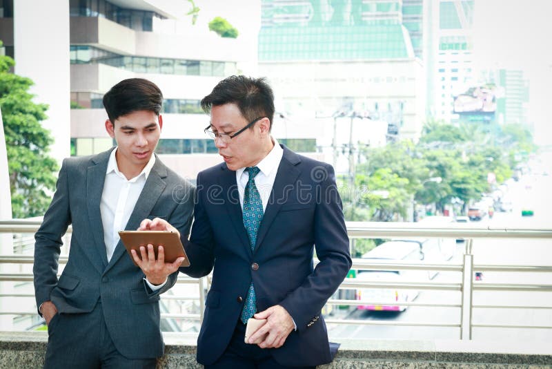 Two Asian Men Wearing Suits Talking To Each Other. Stock Image - Image ...