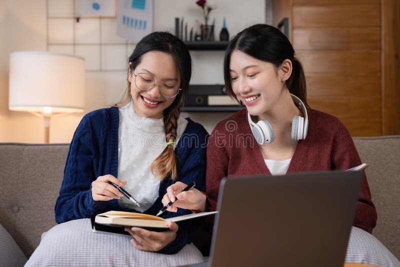 Two Asian Students Learning Together Online with a Laptop and Tutor ... Two Asian Students Learning Together Online with a Laptop and Tutor ...