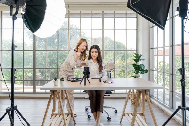 Two Asian Women Creating Content for Social Media. they are Using a Studio Setup that Include a ...
