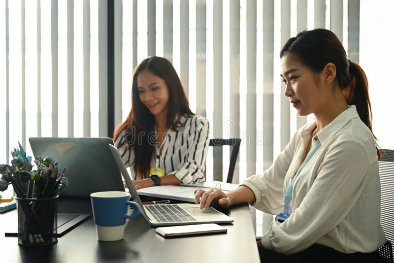 Two Women Office Workers Working Together in Office. Stock Image ...
