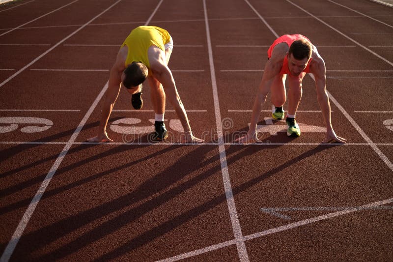Two Athletes in the Stadium are Preparing To Run from a Low Start Stock ...