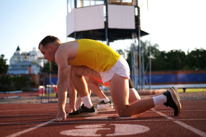 Two Athletes in the Stadium are Preparing To Run from a Low Start Stock ...