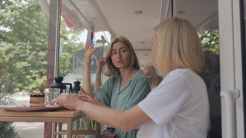 Two Attractive Mature Women Talking Sitting at a Table in a Cafe. Stock ...