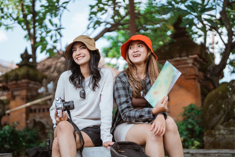 Two Attractive Tourists Sit Holding a Map and a Camera Stock Photo ...