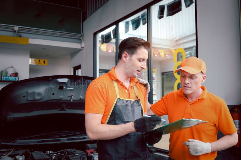 Two Auto Mechanic Worker Men Working with Engine in Garage, Senior and ...