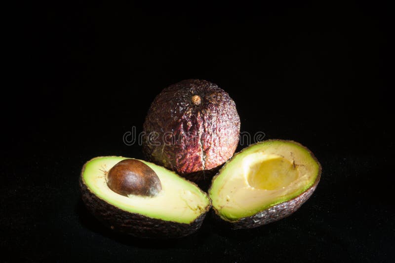 Two Avocado on Black - One Whole, One Inside Stock Image - Image of ...