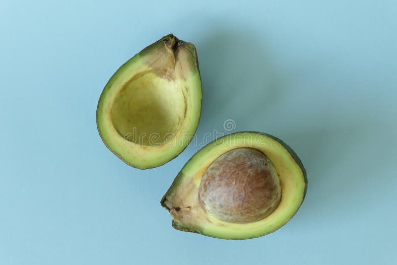 Two Avocado Pieces Isolated on a Blue Background Stock Photo - Image of ...