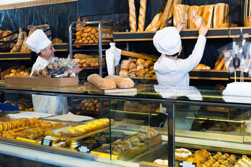 Two Bakers at the Counter at Bakery Stock Photo - Image of ...