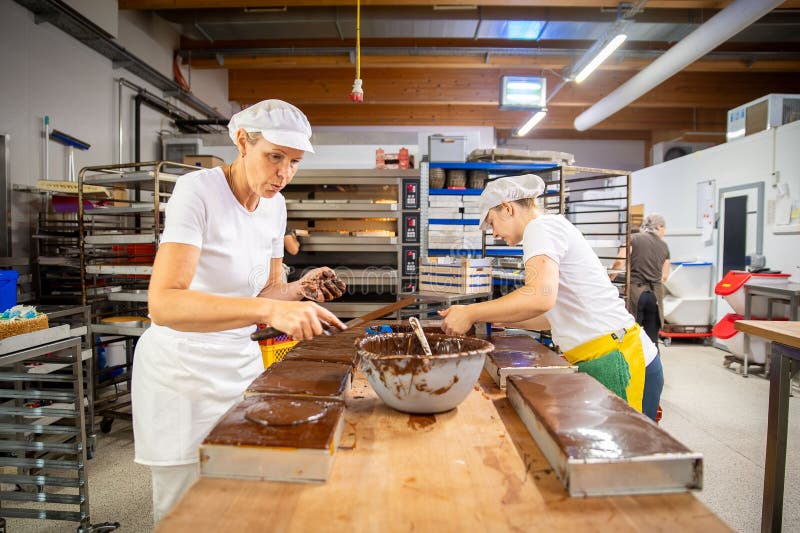 Two Bakers Work Together in a Bakery Kitchen Making Delicious Cakes ...