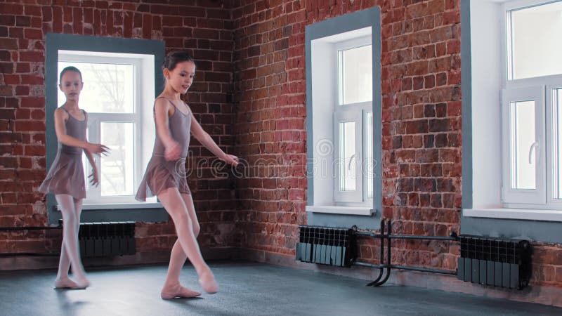 Two Ballerina Girls Performing Synchronized Basic Dancing Movements and ...