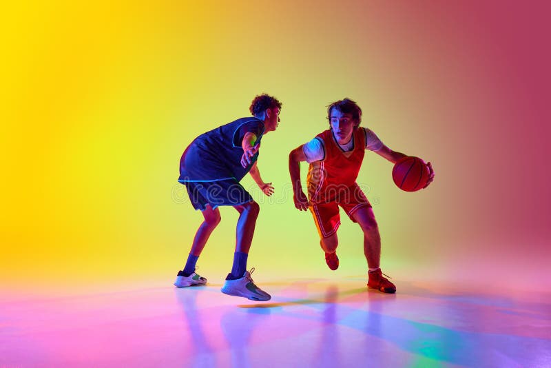 Two Basketball Players Train Under Vivid Lights, Demonstrating Focus ...