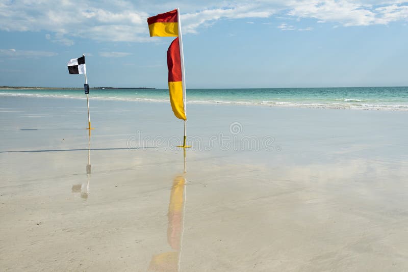 Two Beachside Flags Fluttering Near the Ocean S Edge. Stock Photo ...