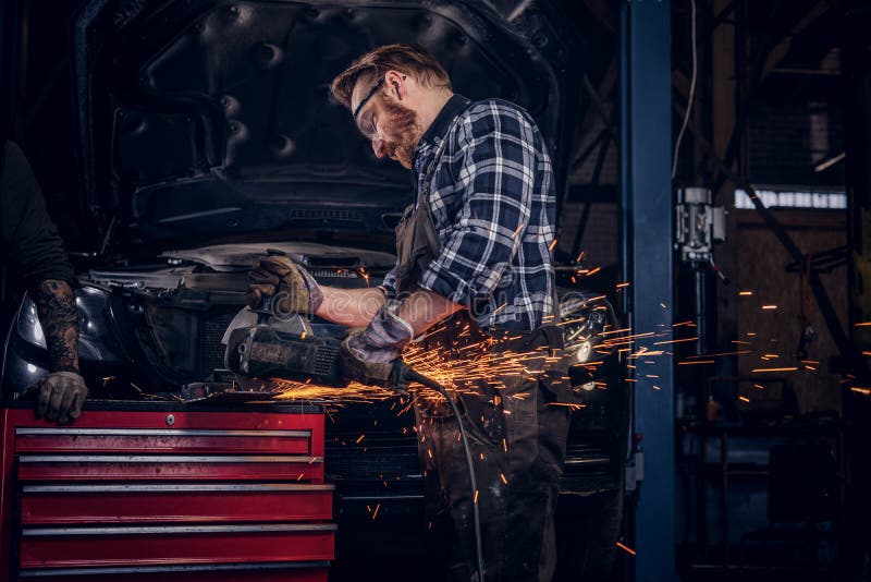 Two Bearded Auto Mechanic in a Uniform and Safety Glasses Working with ...