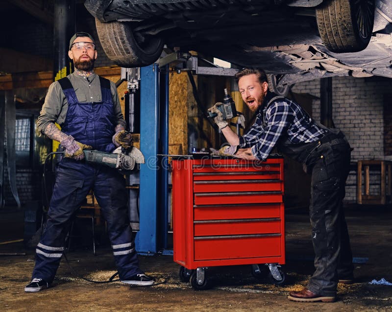 Two Bearded Mechanics with an Angle Grinder. Stock Photo - Image of ...
