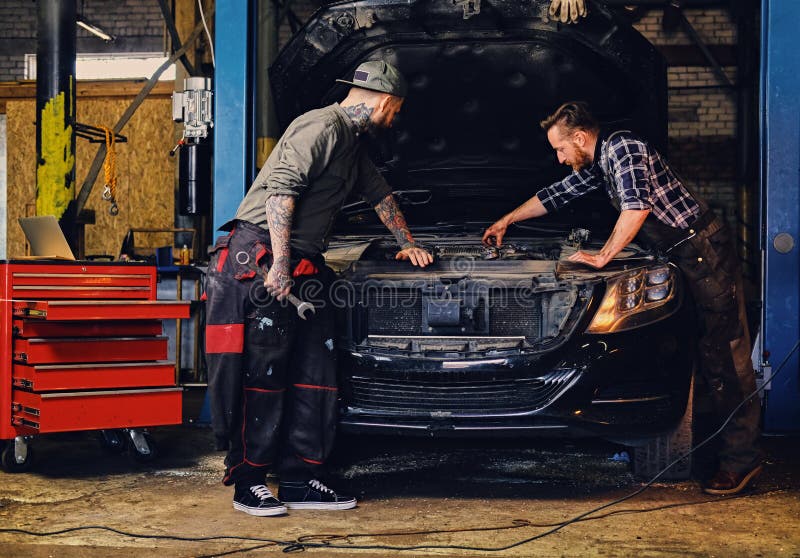 Two Mechanics Fixing Car`s Engine in a Garage. Stock Photo - Image of ...