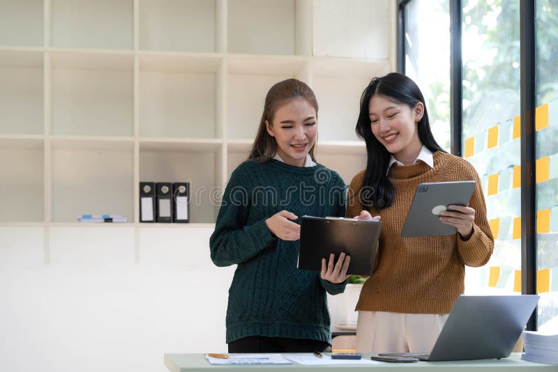 Two Beautiful Asian Businesswomen Standing Using Digital Tablet ...