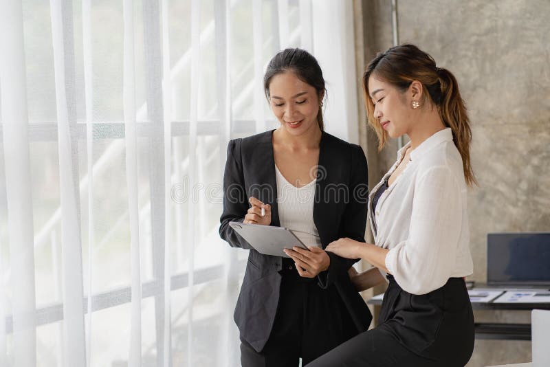 Two Beautiful Asian Women Consulting a Collaborative Structure Using ...