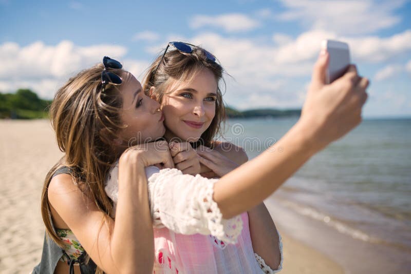 Two Beautiful Female Friends Taking Selfie On Beach Having Fun Stock