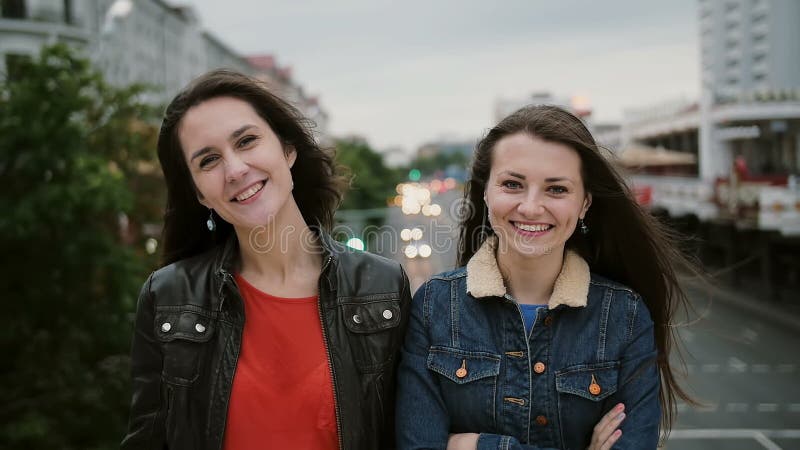 Two Beautiful Girls Standing On The Bridge Smiling Laughing And Looks