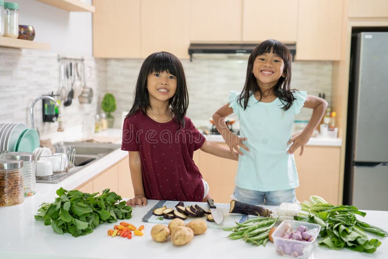 Two Beautiful Little Girl Preparing and Cooking Dinner in the Kitchen ...