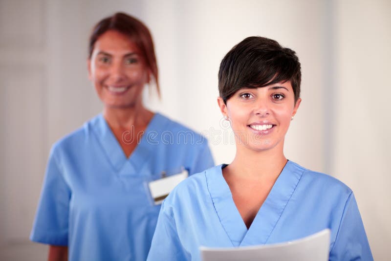 Two Beautiful Nurse Looking and Smiling at You Stock Image - Image of ...