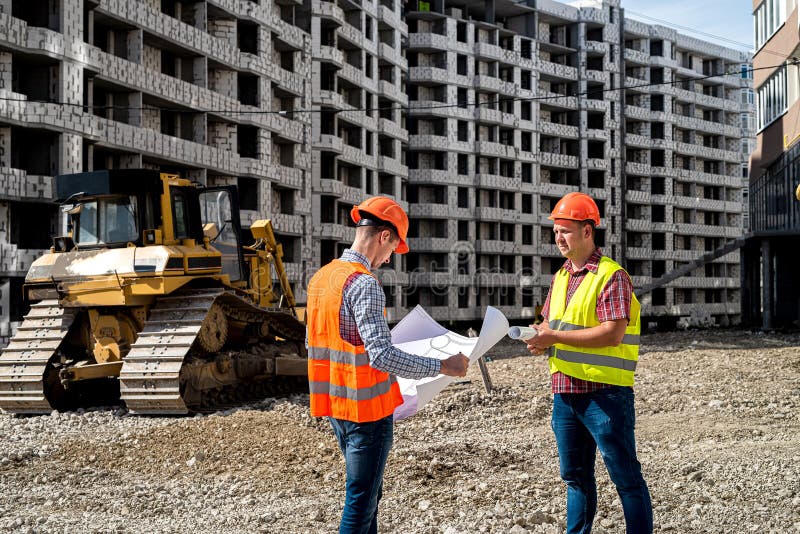 Two Beautiful Workers in Uniform on a Construction Site are Considering ...